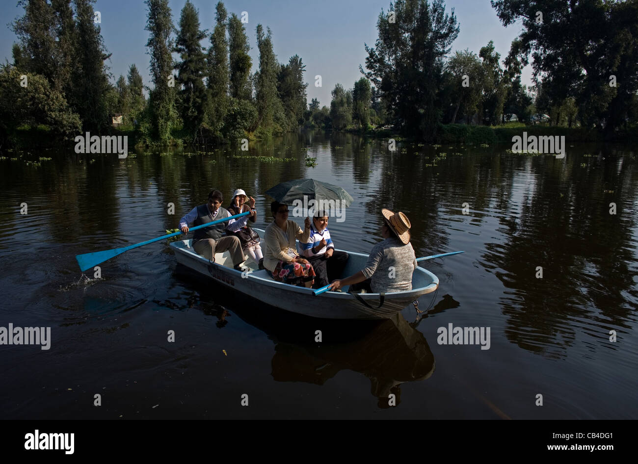 A family use a boat through a canal a sunday morning in Xochimilco ...