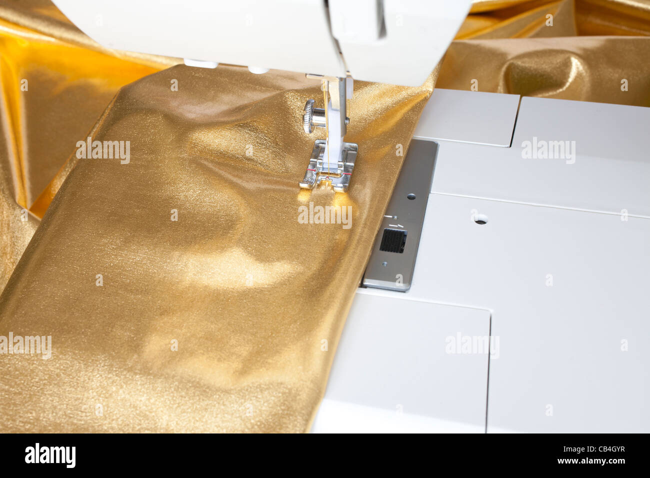 machine sewing with gold material Stock Photo - Alamy