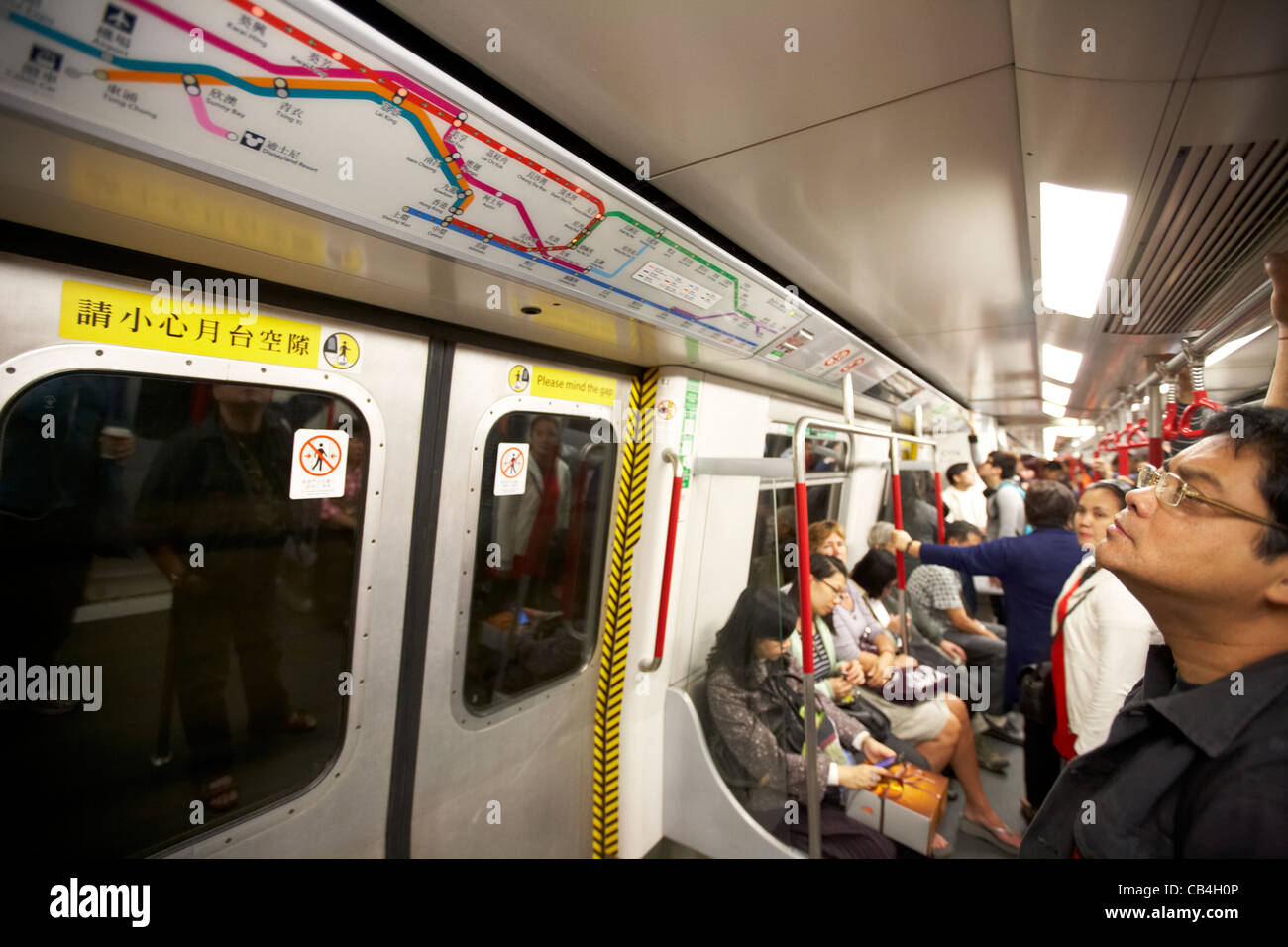 male asian passenger looking at map of mtr underground on train in ...