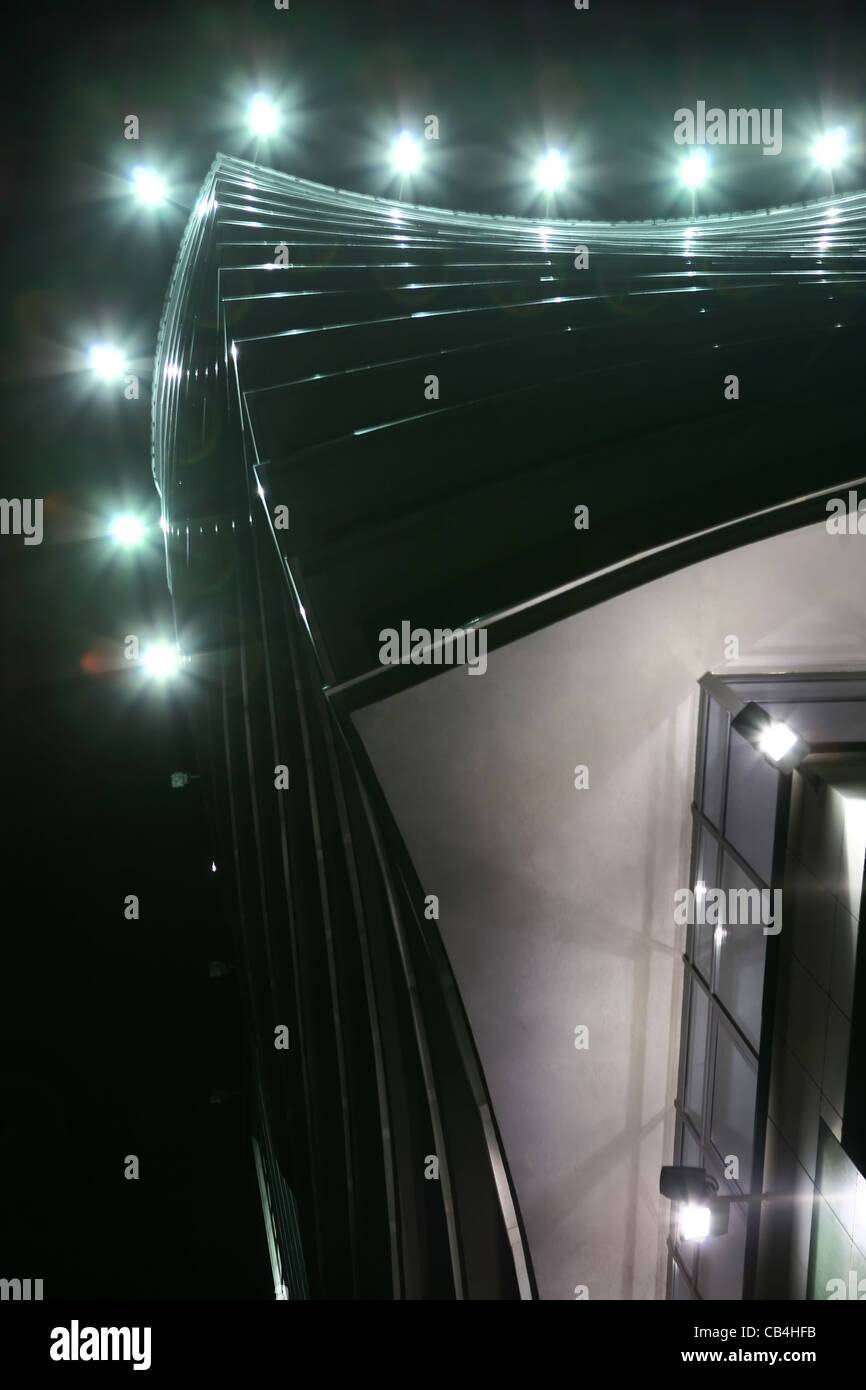 Night view of the modern high-rise building illuminated with lamps from ...