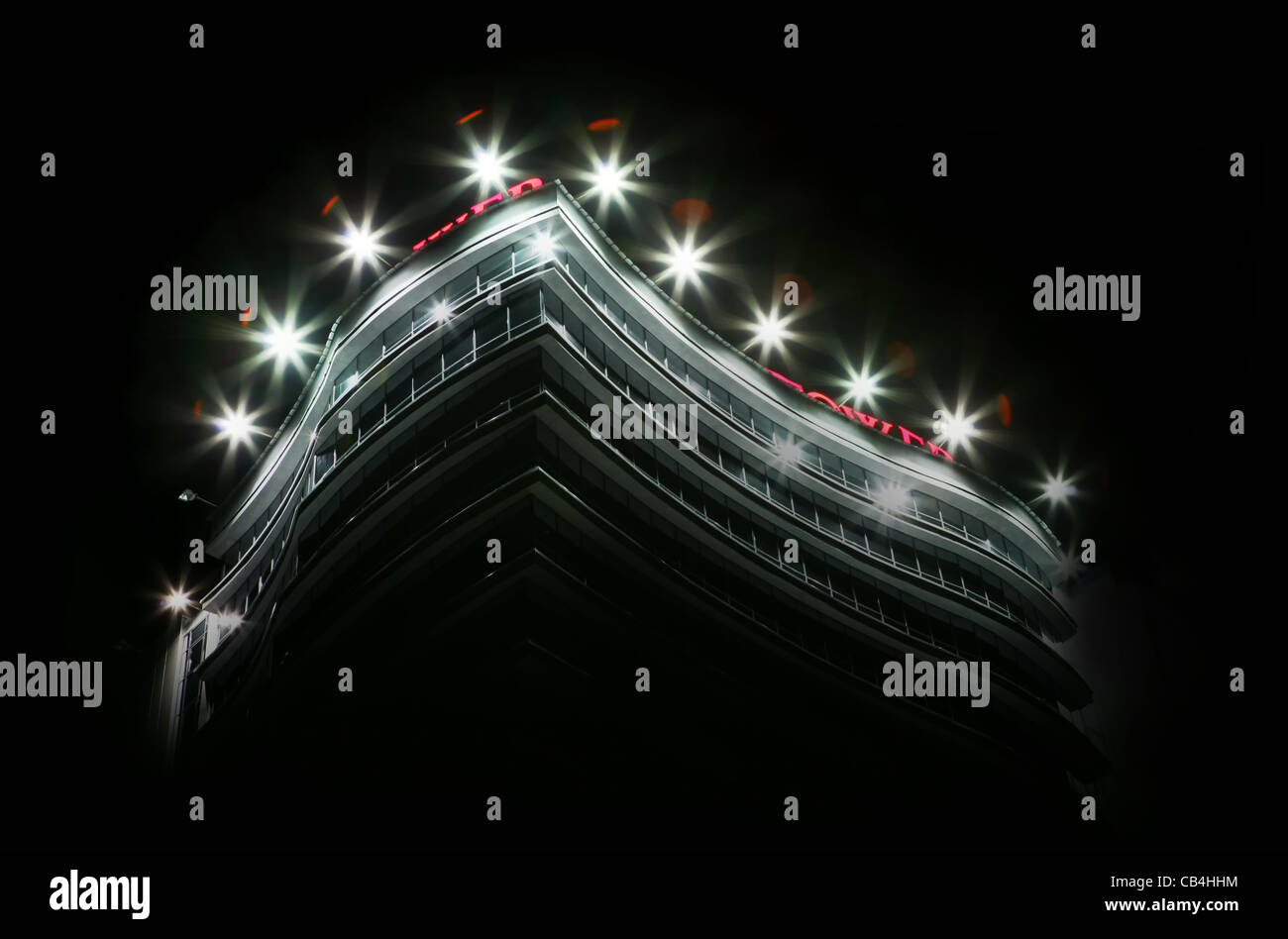 Night view of the modern high-rise building illuminated with lamps from ...