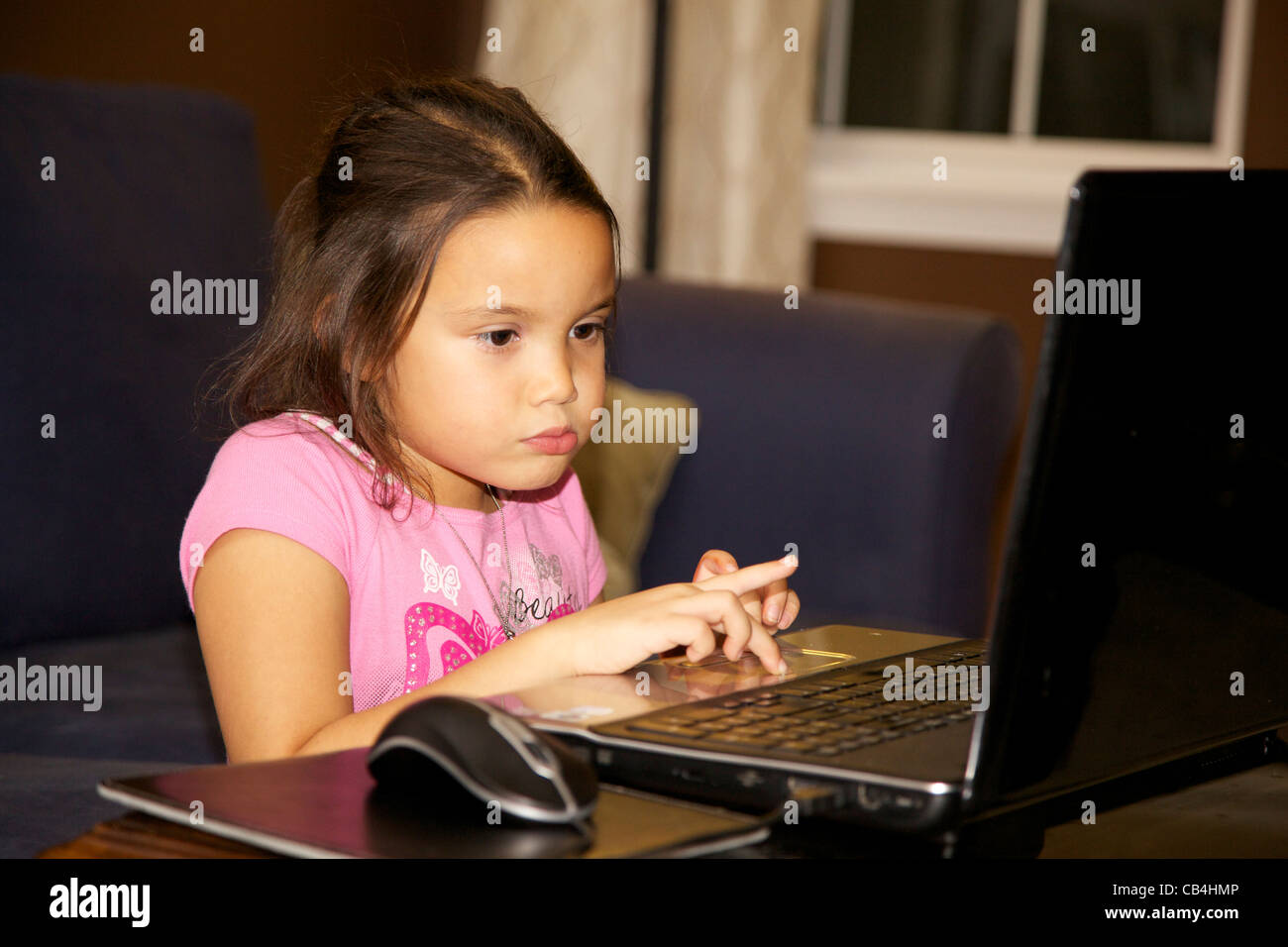 Seven year old girl using laptop computer Stock Photo - Alamy