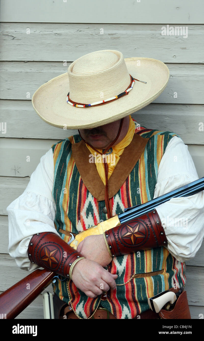 A cowboy leaning on a building Stock Photo - Alamy