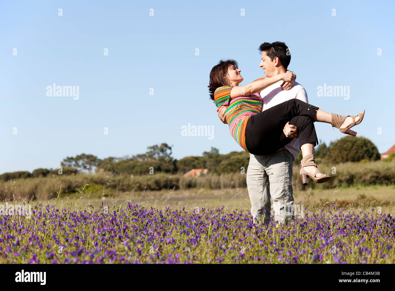 young couple hug in a field with beautiful flowers Stock Photo - Alamy