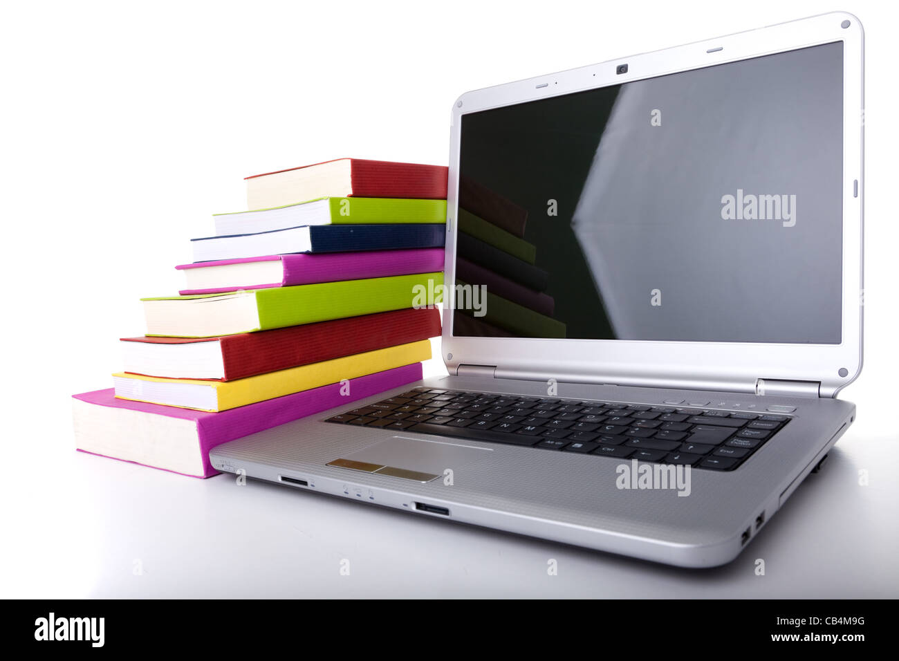 Colorful books next to a modern laptop Stock Photo - Alamy