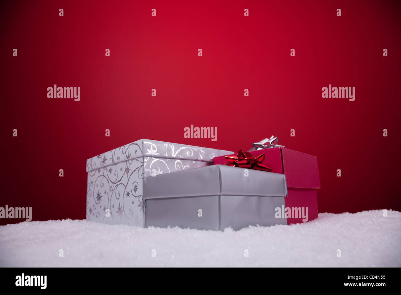 three christmas presents with a red background Stock Photo - Alamy