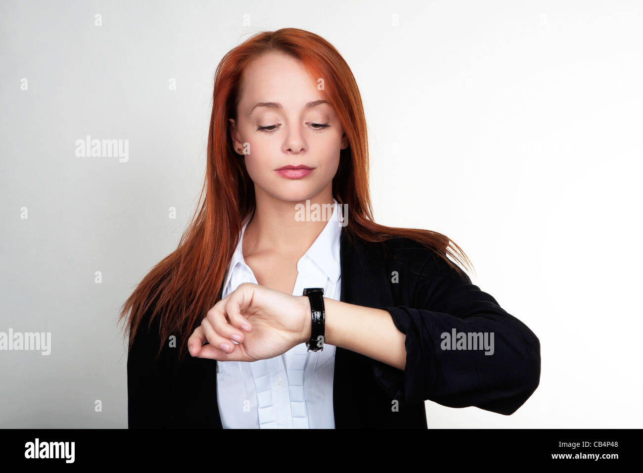 woman in a suit looking at her watch Stock Photo - Alamy