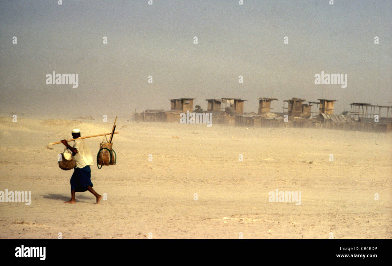 A poor migrant worker walking home through a desert sand-storm, Dubai ...