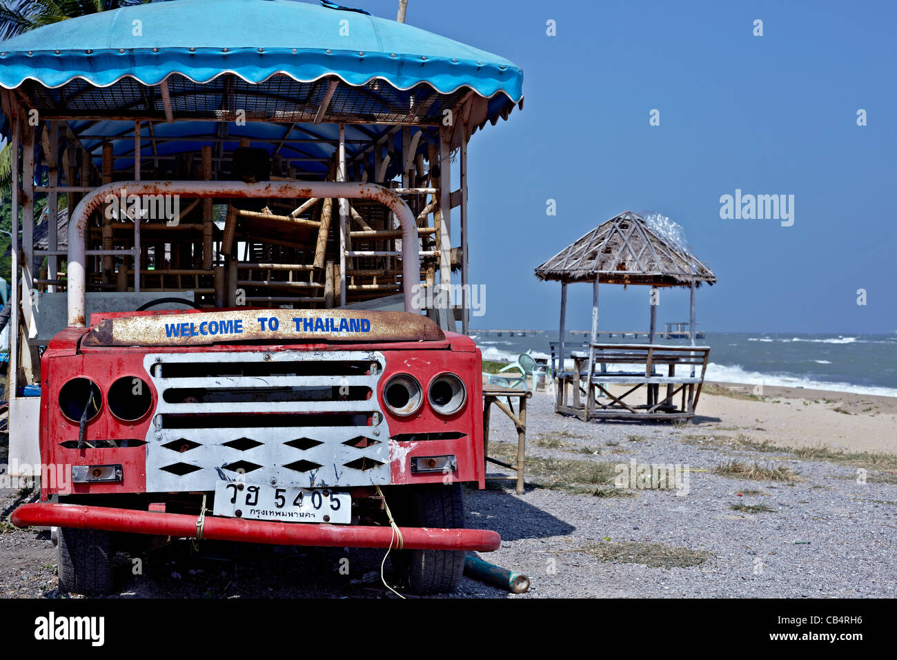 Rusting and abandoned vehicle on the beach with ironic "Welcome to ...