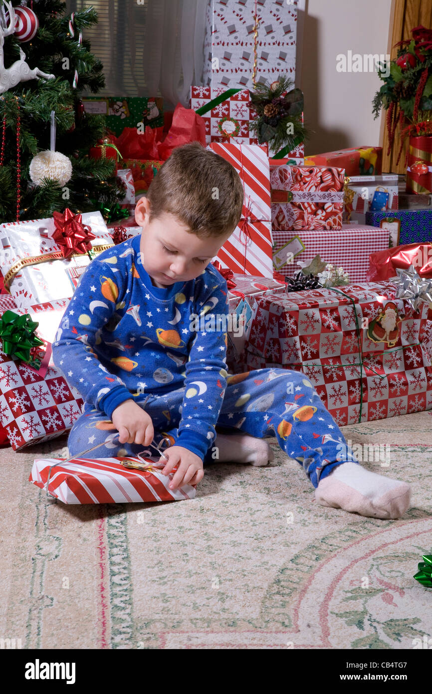 Child opening presents near the Christmas tree, Holiday has finally ...