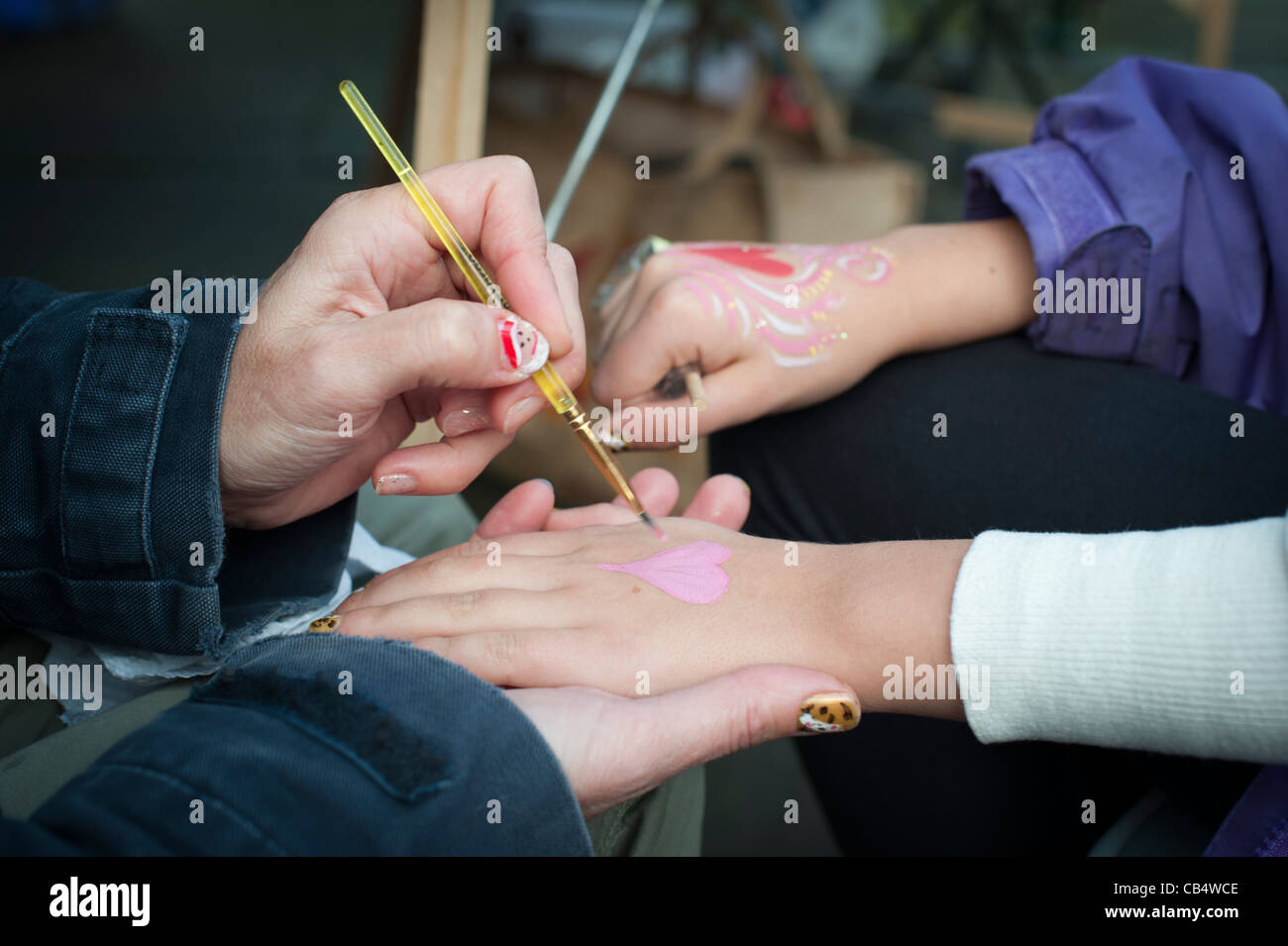 Hand painting. Hands being decorated with paint Stock Photo - Alamy