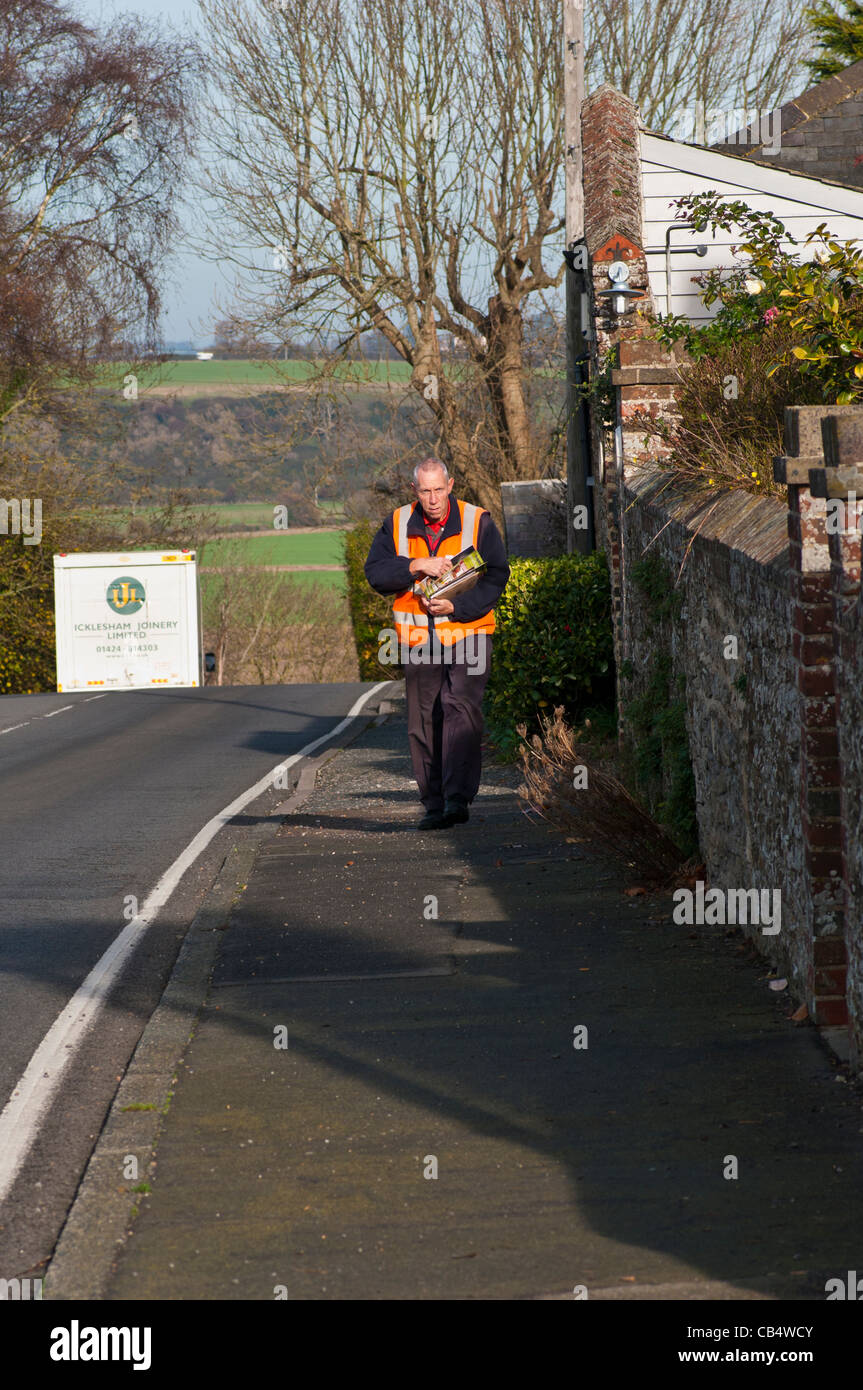 Rural Village Postman Walking Along The Street With The Mail Post UK ...