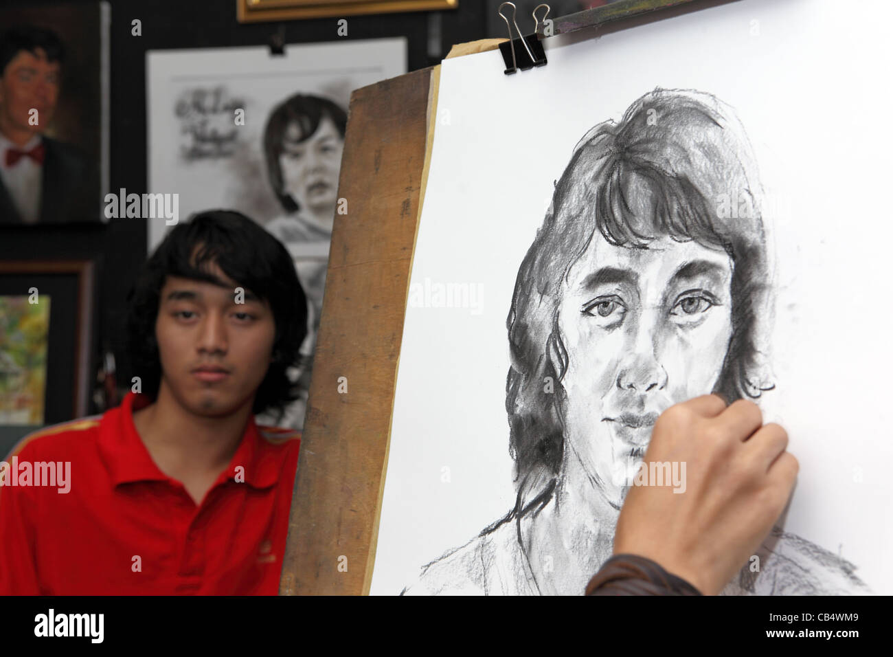 An artist at the Central Market sketches the portrait of a young man ...