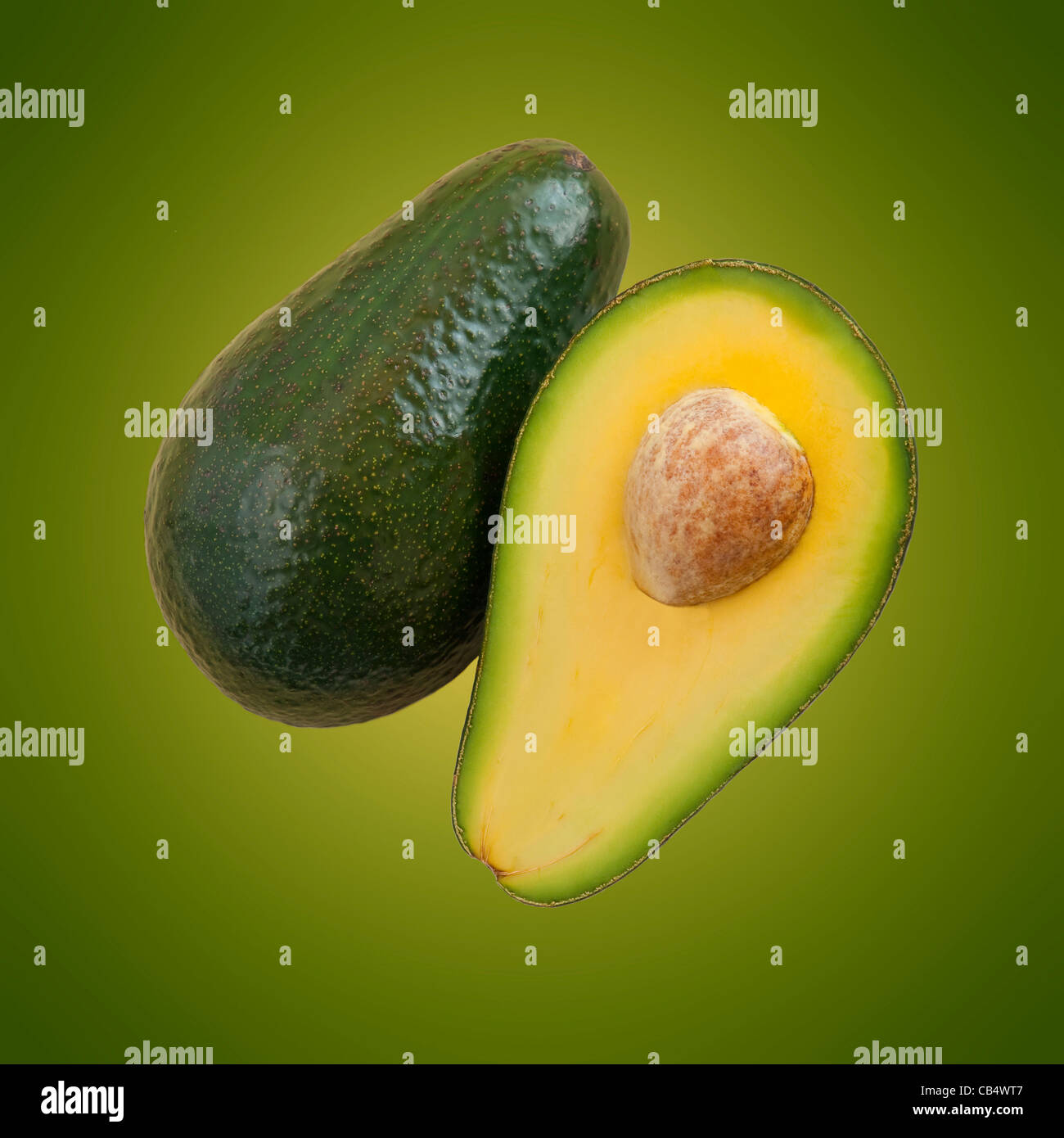 Split avocado pieces viewed from above with glowing green background ...