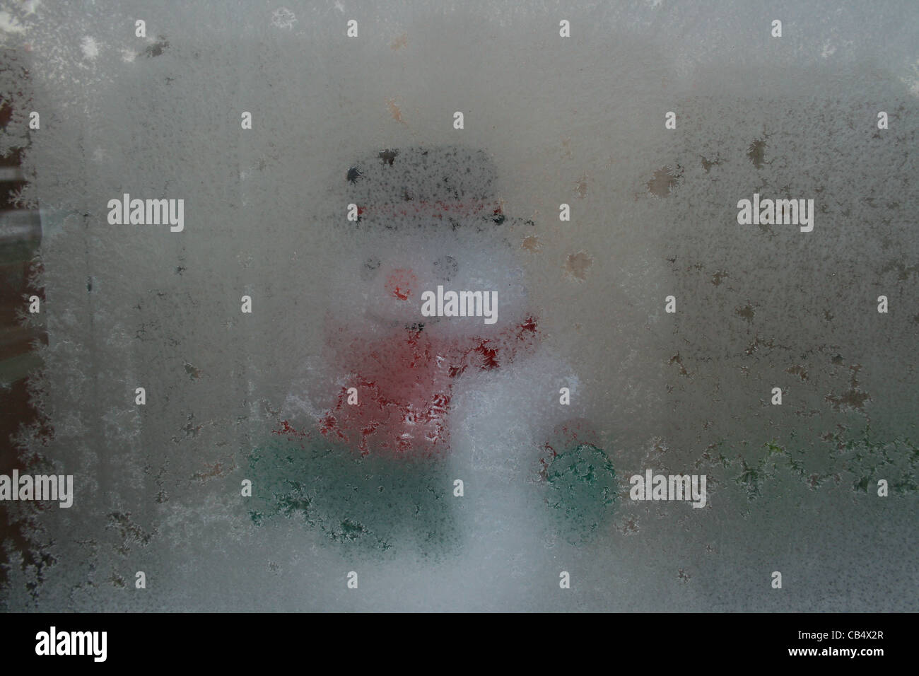 Toy snowman looking through frosted glass window Stock Photo - Alamy