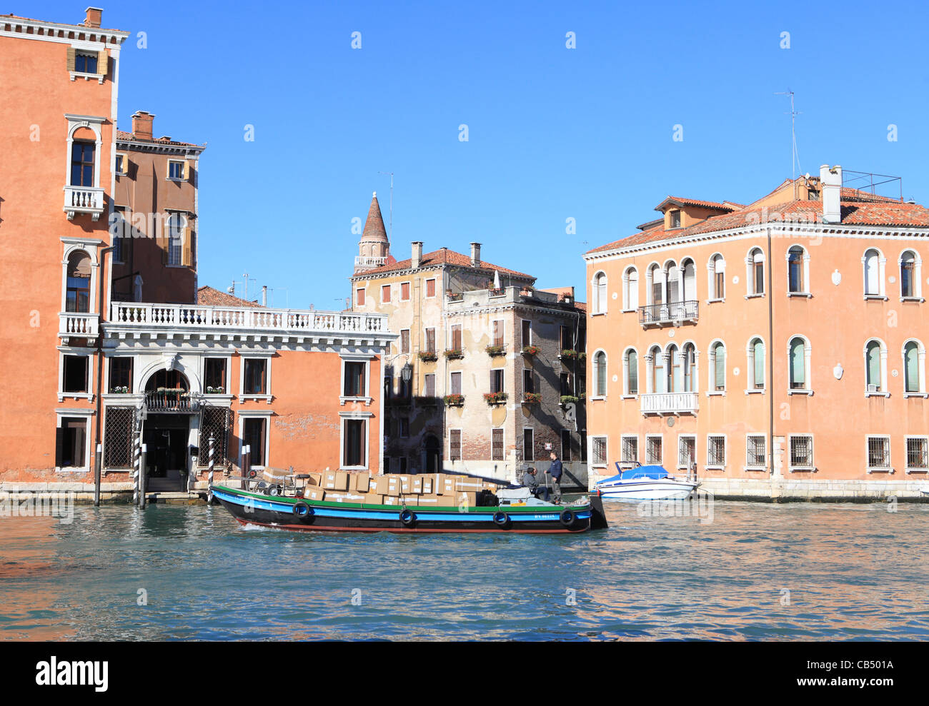 A boat carrying cardboard boxes on the Grand Canal in Venice, Italy ...