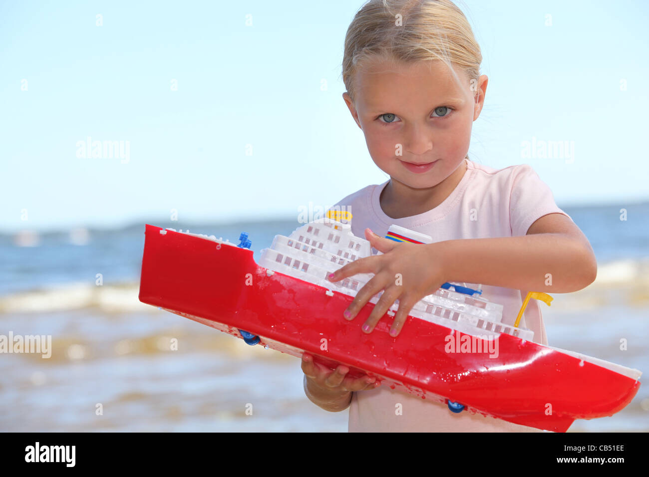Girl playing with boat Stock Photo - Alamy