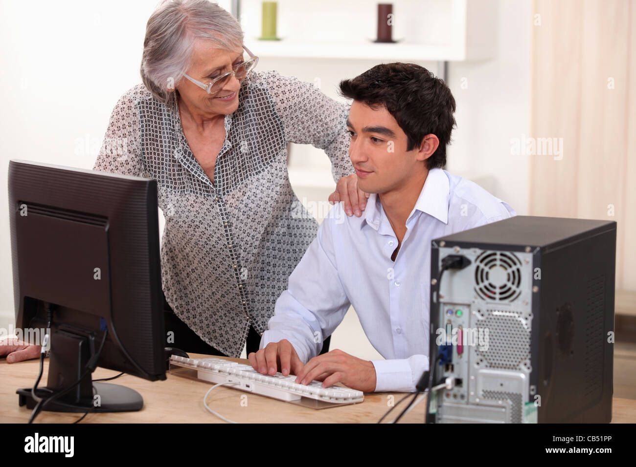 Man helping elderly woman with computer problems Stock Photo - Alamy