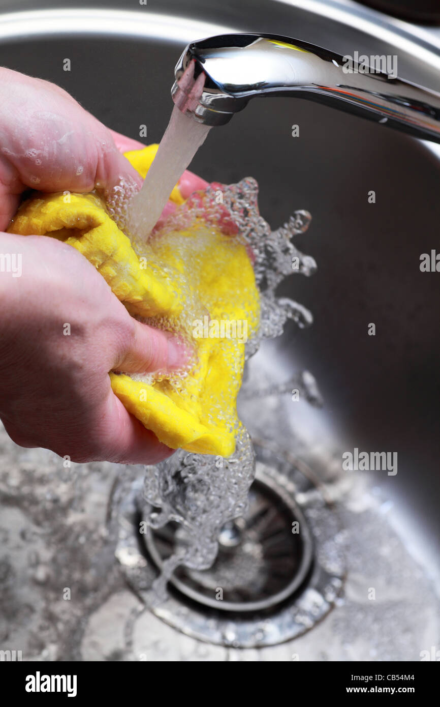 yellow cloth and hands under running water Stock Photo - Alamy