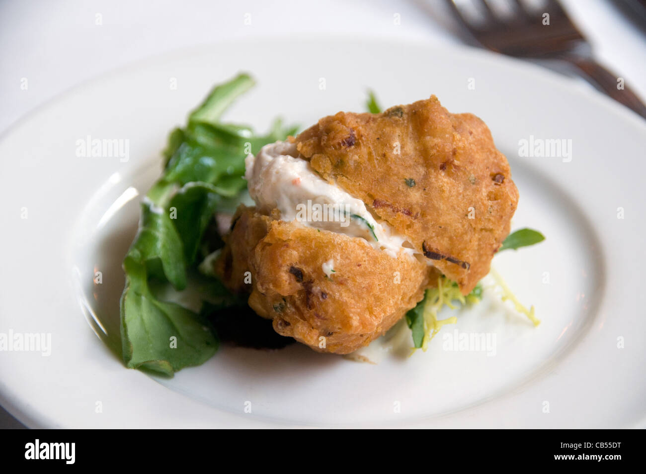 A shrimp beignet, a savoury pastry appetizer, served at a restaurant in ...