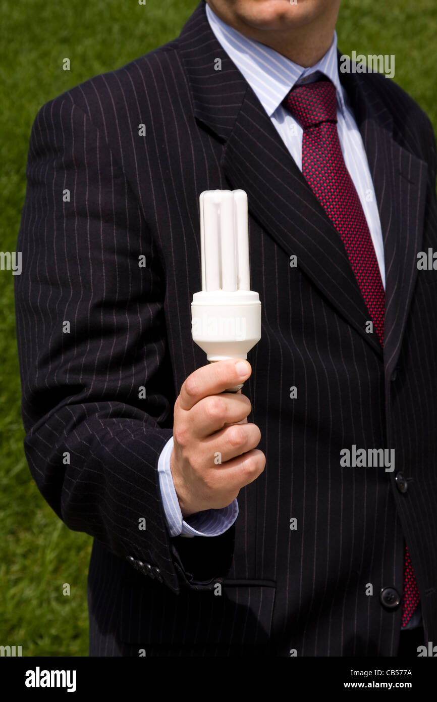 a businessman holding a economic lamp, conceptual idea and creativity ...