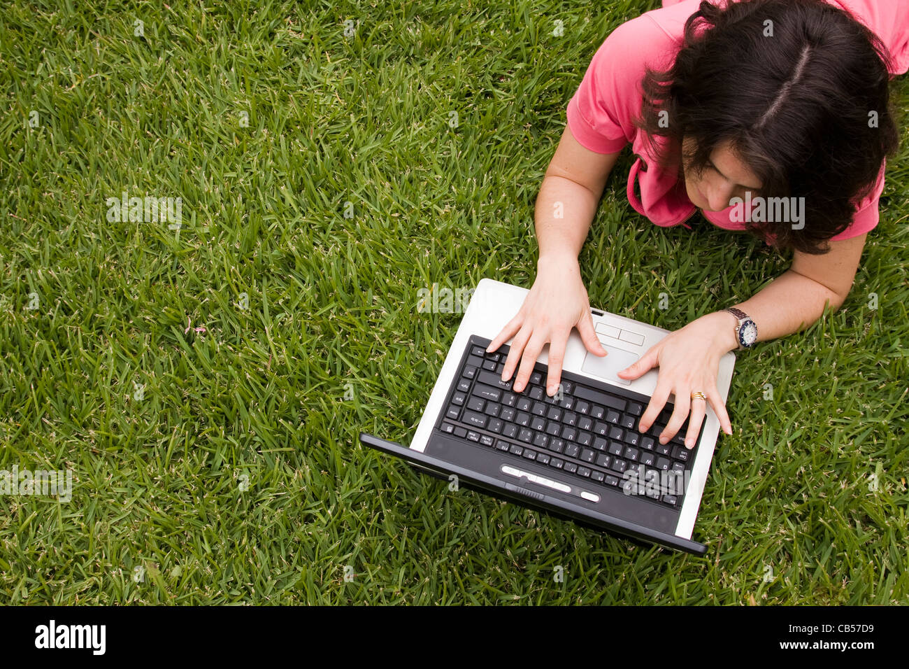 woman connecting the internet with her laptop at the park (above view ...