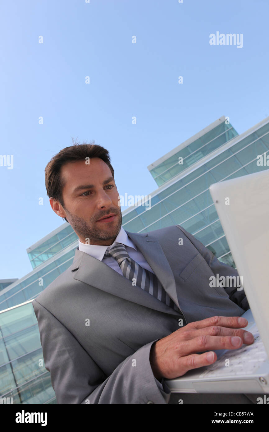 Businessman on laptop outside Stock Photo - Alamy