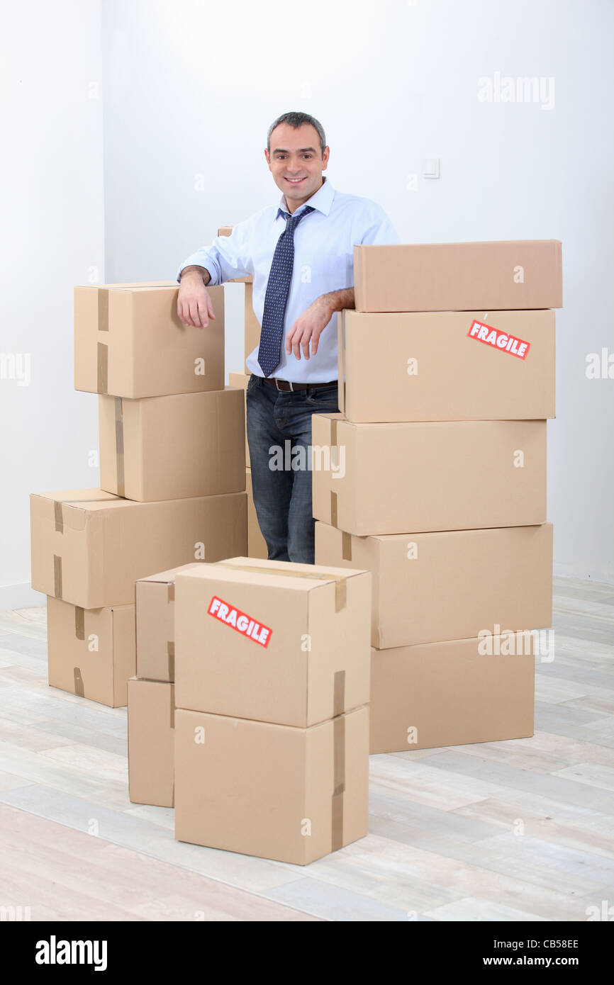 Man with piles of cardboard boxes marked fragile Stock Photo - Alamy