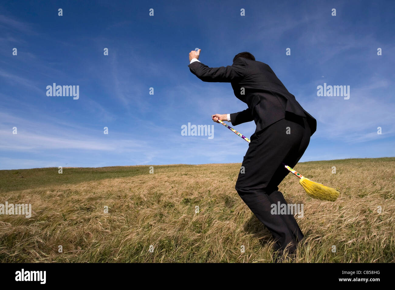 businessman wizard flying at the field with his magical broom Stock ...