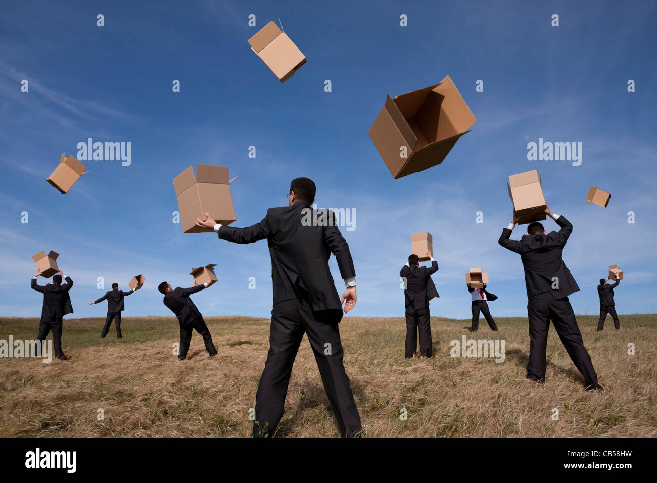 a group of businessmans in the field with cardboard boxes (some motion ...