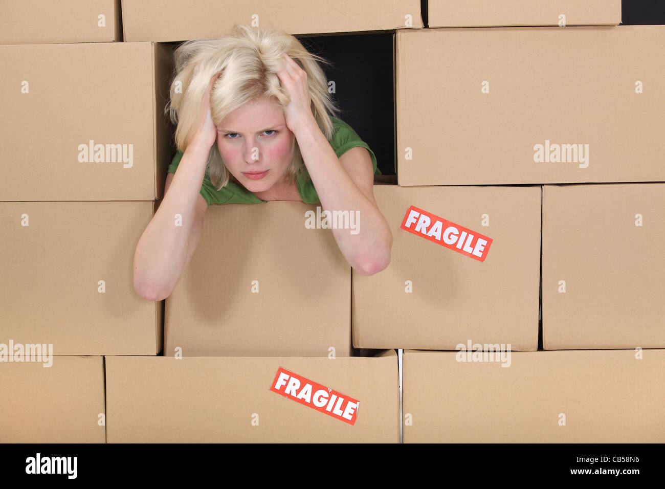 Stressed woman surrounded by boxes Stock Photo - Alamy