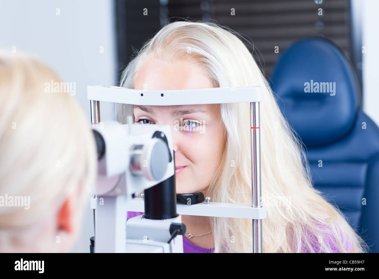 optometry concept - pretty, young female patient having her eyes ...