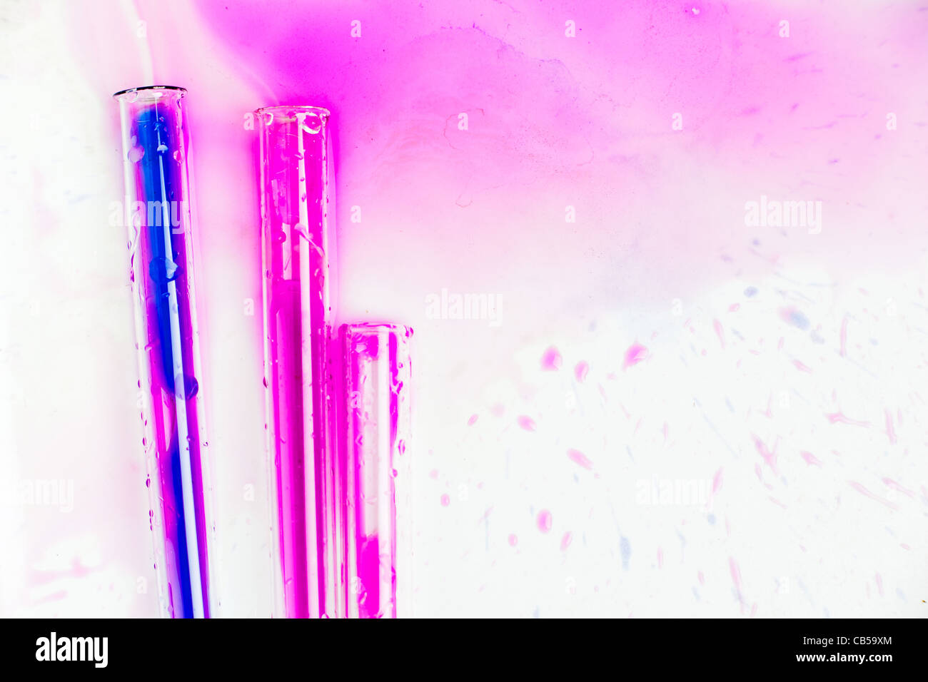 test tubes with colorful substances spilled on a white table in a lab ...