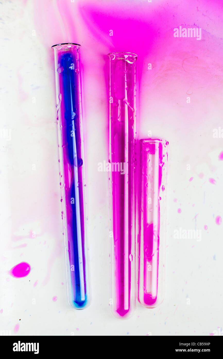 test tubes with colorful substances spilled on a white table in a lab ...