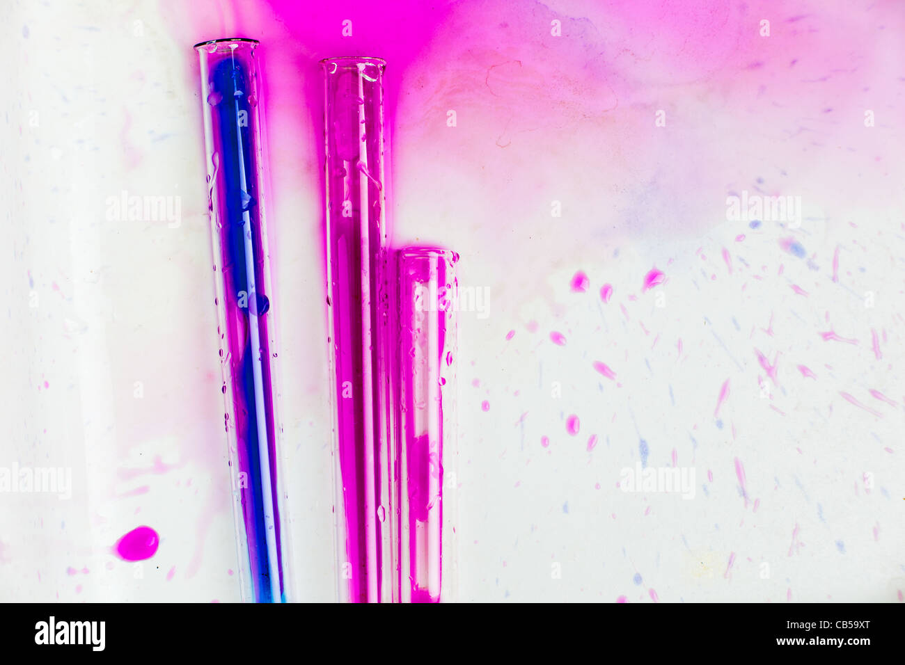 test tubes with colorful substances spilled on a white table in a lab ...