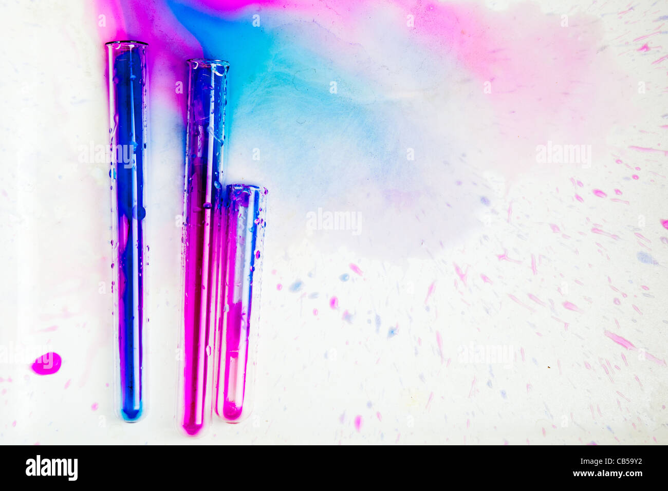 test tubes with colorful substances spilled on a white table in a lab ...