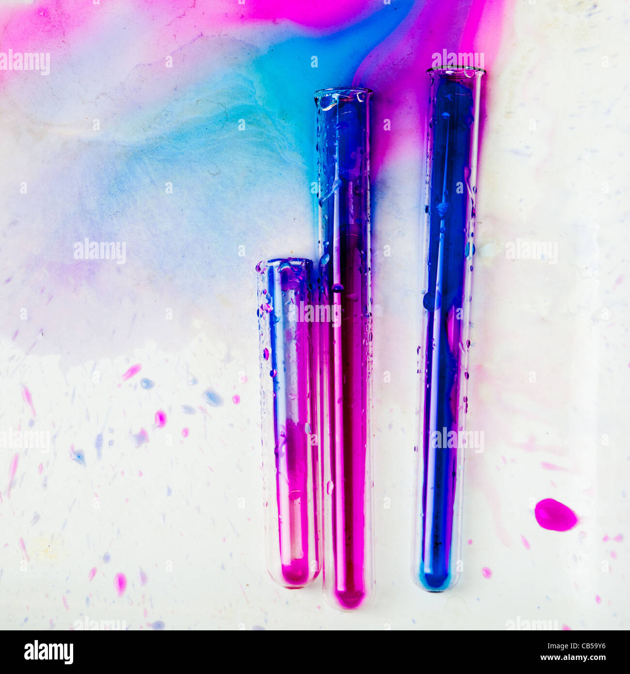 test tubes with colorful substances spilled on a white table in a lab ...