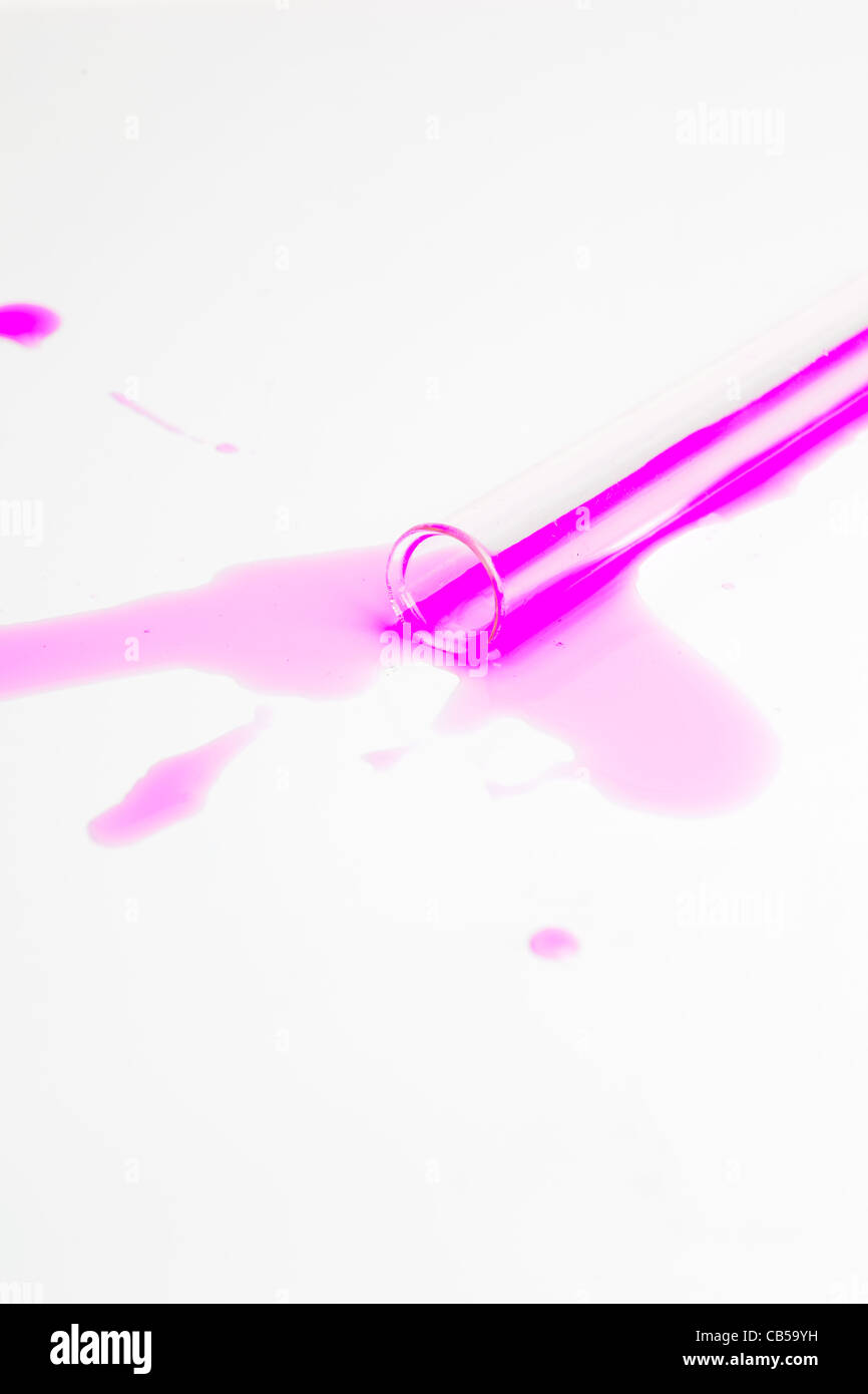 test tubes with colorful substances spilled on a white table in a lab ...