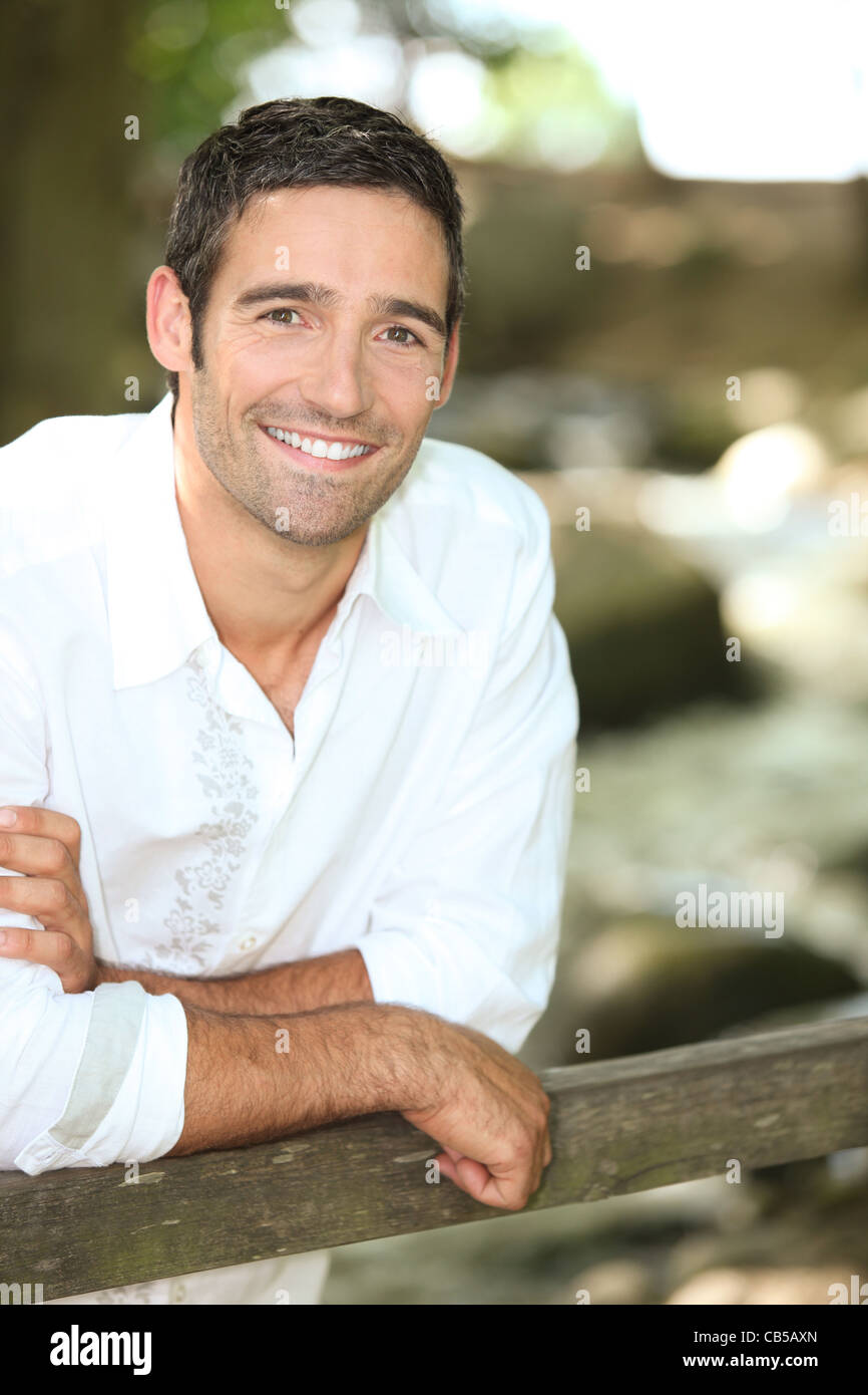 Smiling man leaning on a country gate Stock Photo - Alamy