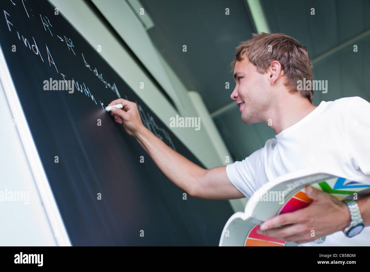 handsome college student solving a math problem during math class in ...