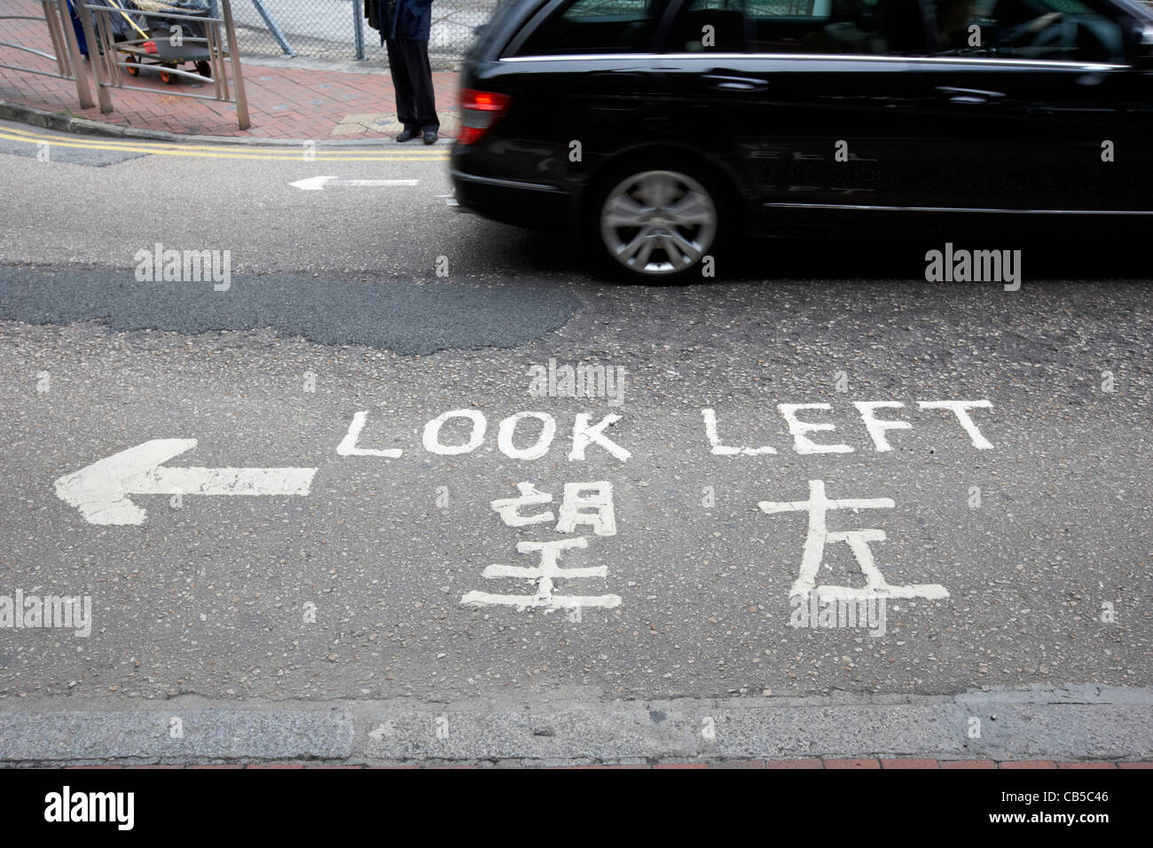 car passing look left signs on the road in english and chinese ...