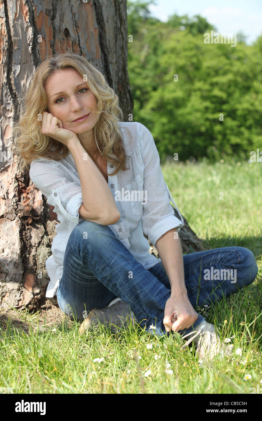 Woman relaxing under a tree Stock Photo - Alamy