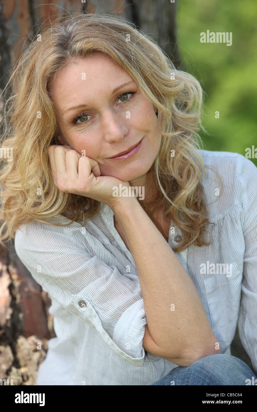 Woman smiling under tree Stock Photo - Alamy