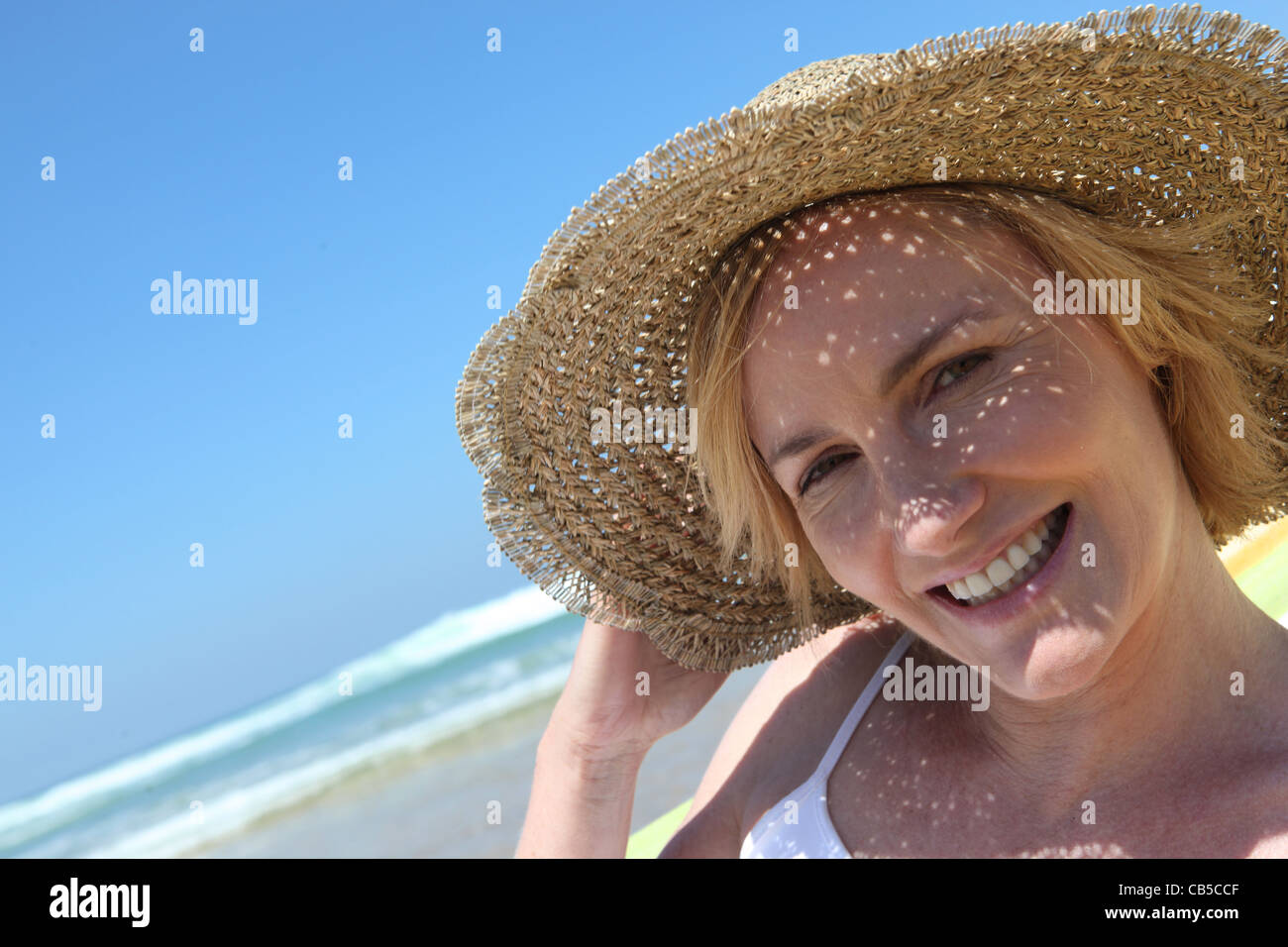 Woman at the beach wearing straw hat Stock Photo - Alamy