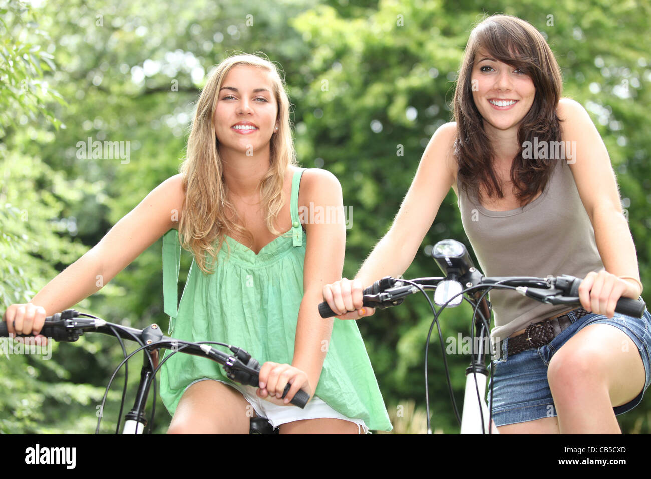Two teenage girls riding bikes in the countryside Stock Photo - Alamy