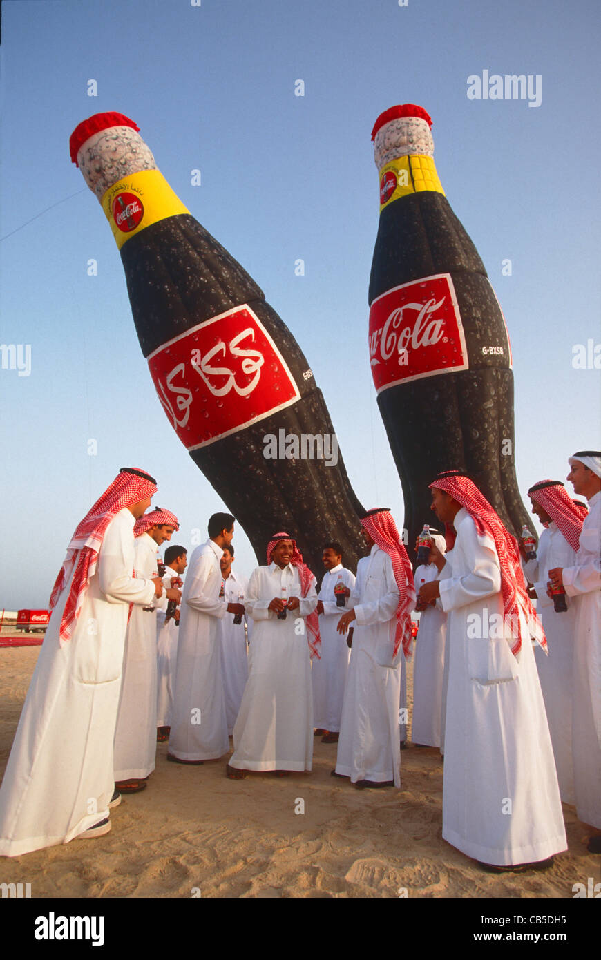 Young Saudi men drink Coca-Cola in front of two giant tethered hot-air ...