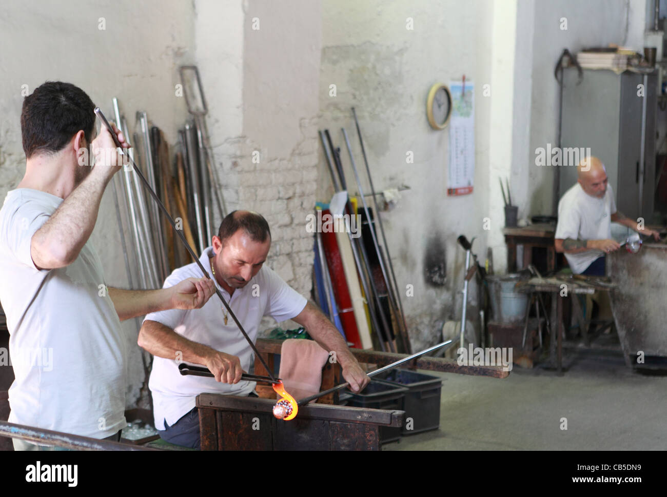 A craftsman in a Murano factory works on the production of a piece of ...