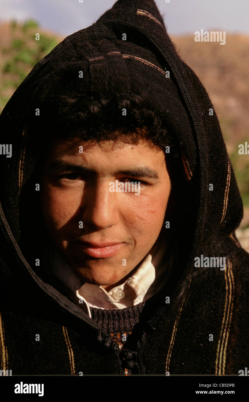A boy in the High Atlas mountains, Morocco wears a traditional hooded ...