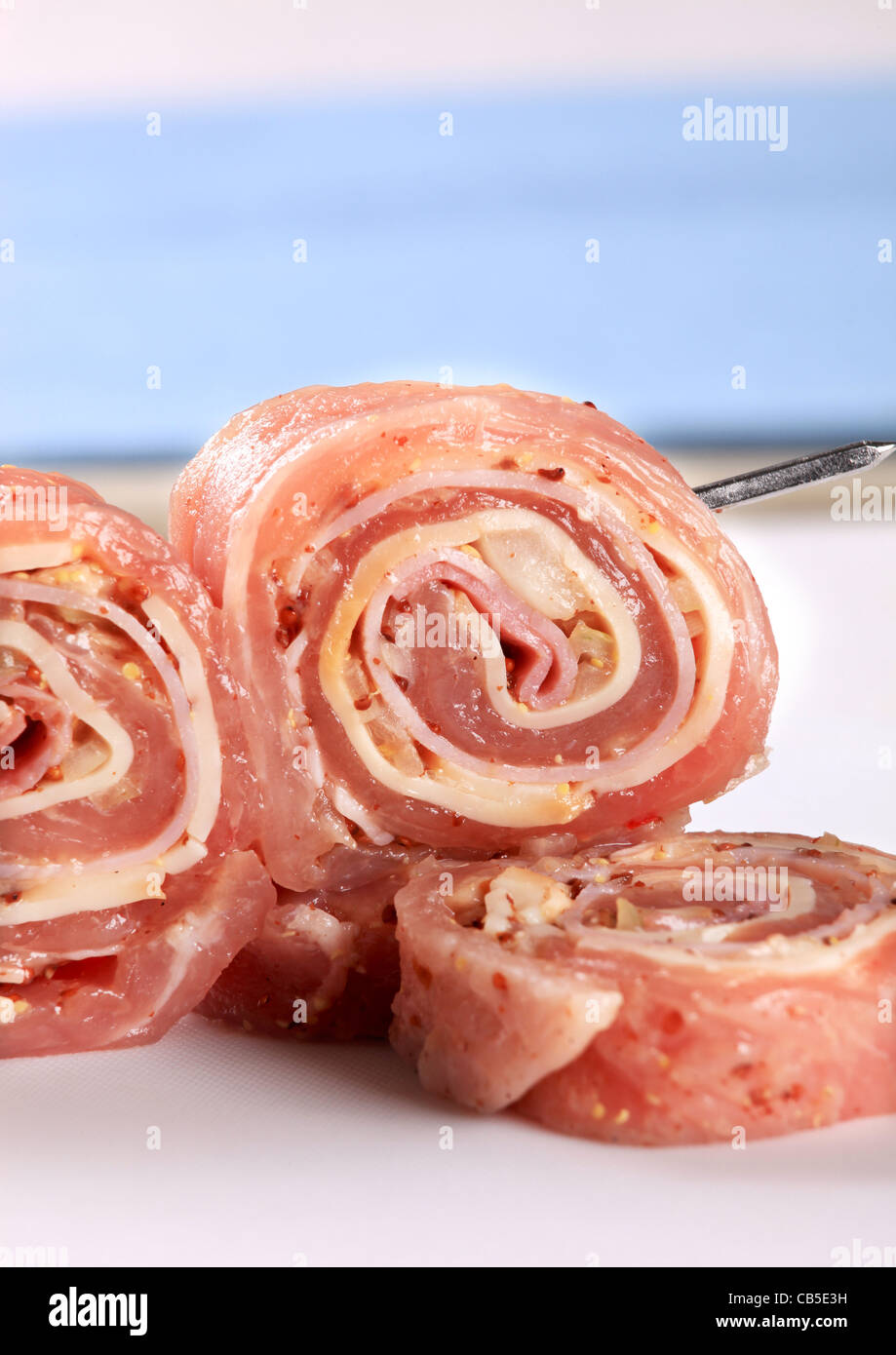 Raw meat rolls stuffed with cheese and ham Stock Photo - Alamy