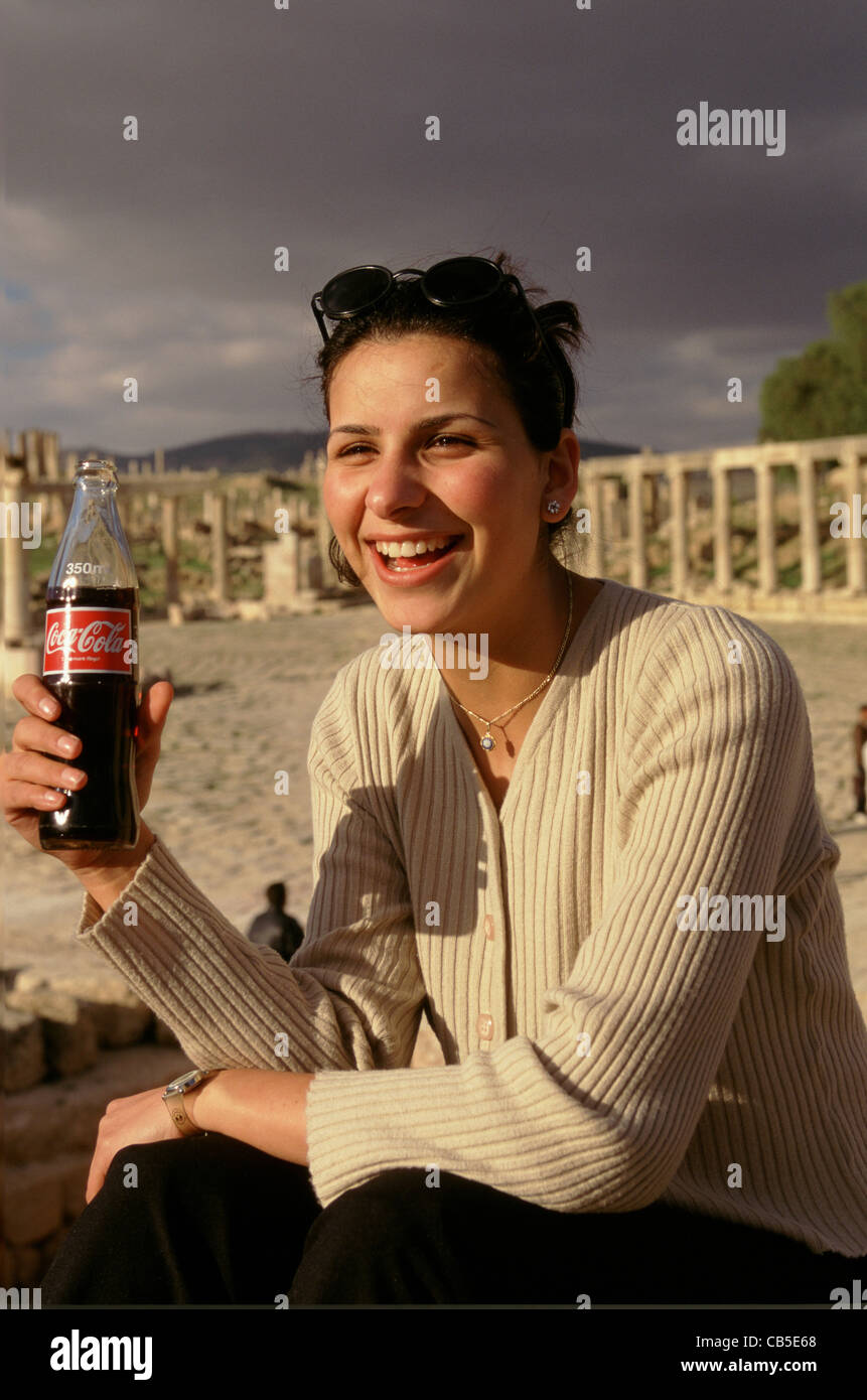 Young woman drinks a coke among the Greco-Roman ruins at Jerash, 48 kms ...